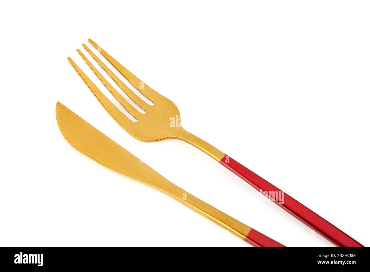 Golden fork and knife with red handles on white background Stock Photo ...
