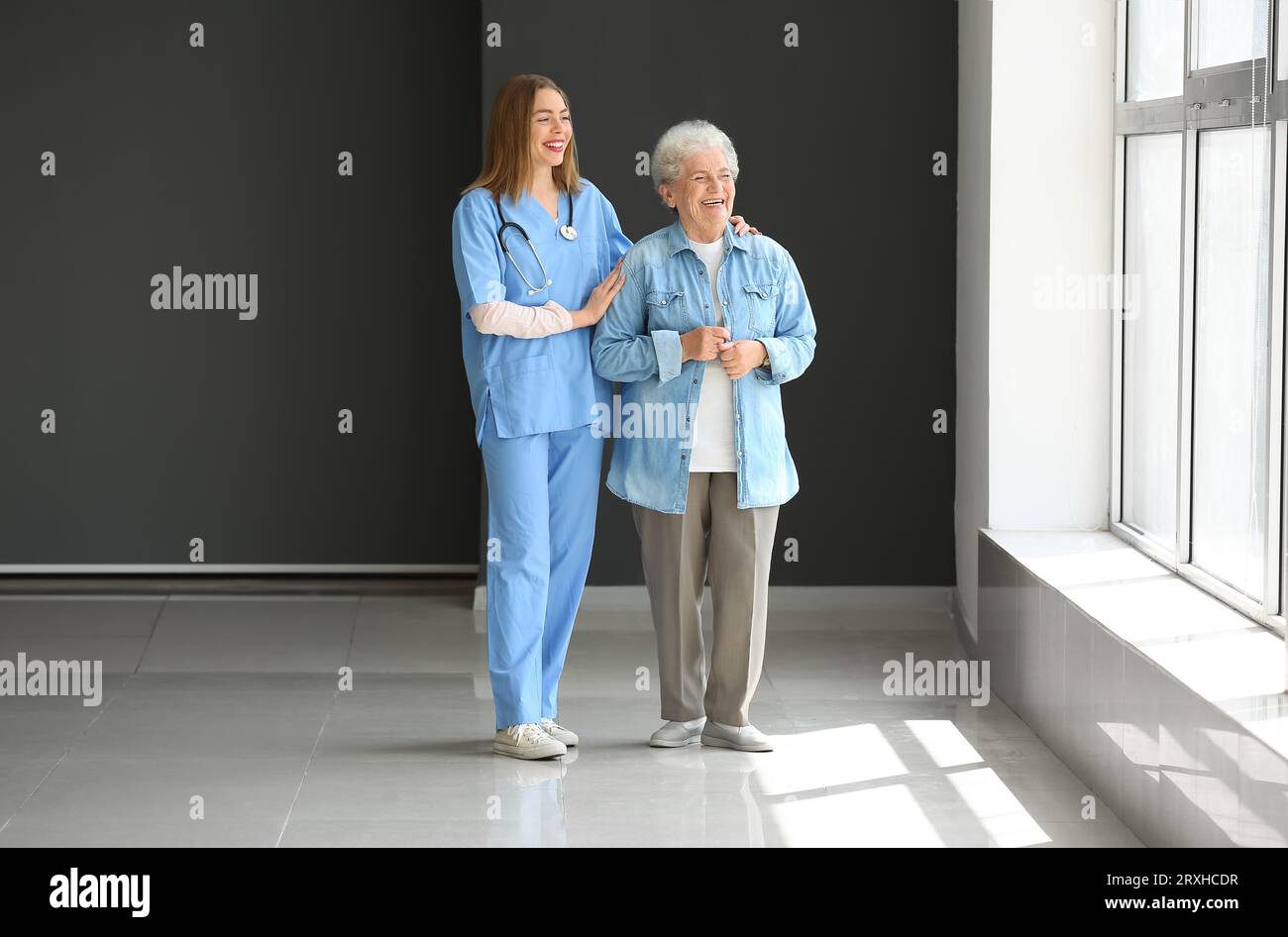 Female caregiver with senior woman in room Stock Photo - Alamy
