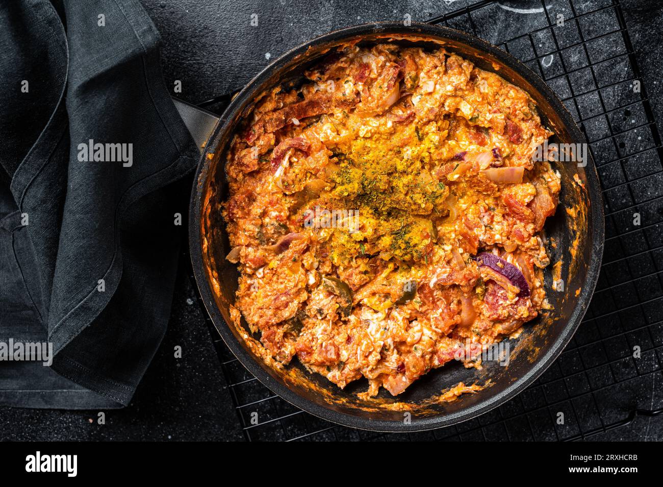 Turkish Menemen omelet in a frying pan. Black background. Top view ...