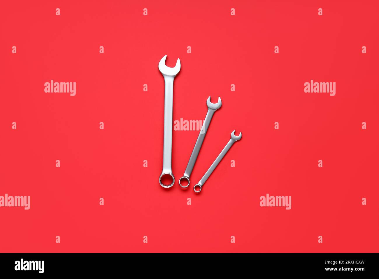 Different spanners on a red background Stock Photo - Alamy