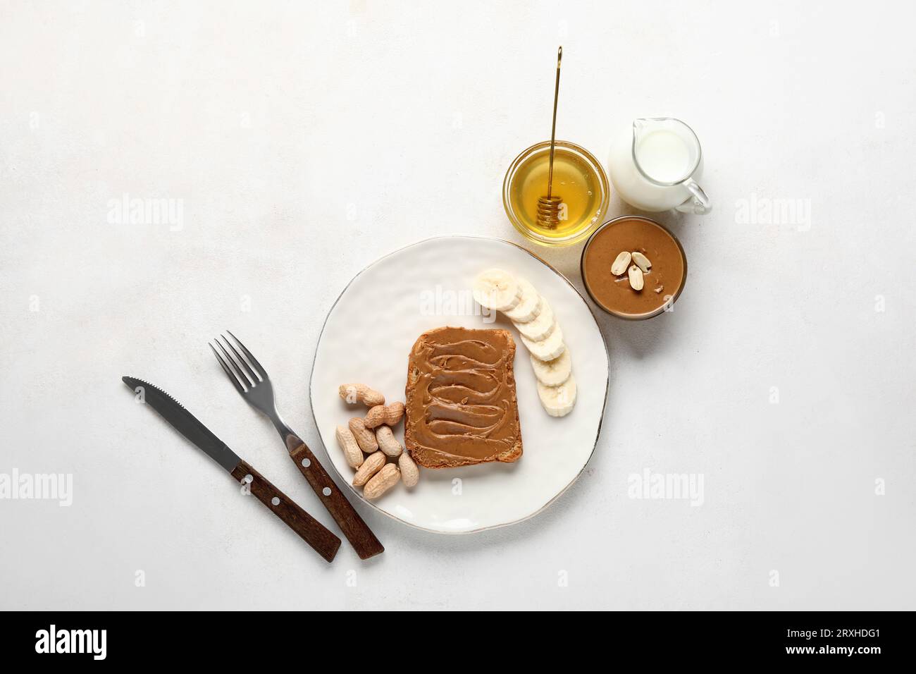 Plate of toast with peanut butter, banana and nuts on white background ...