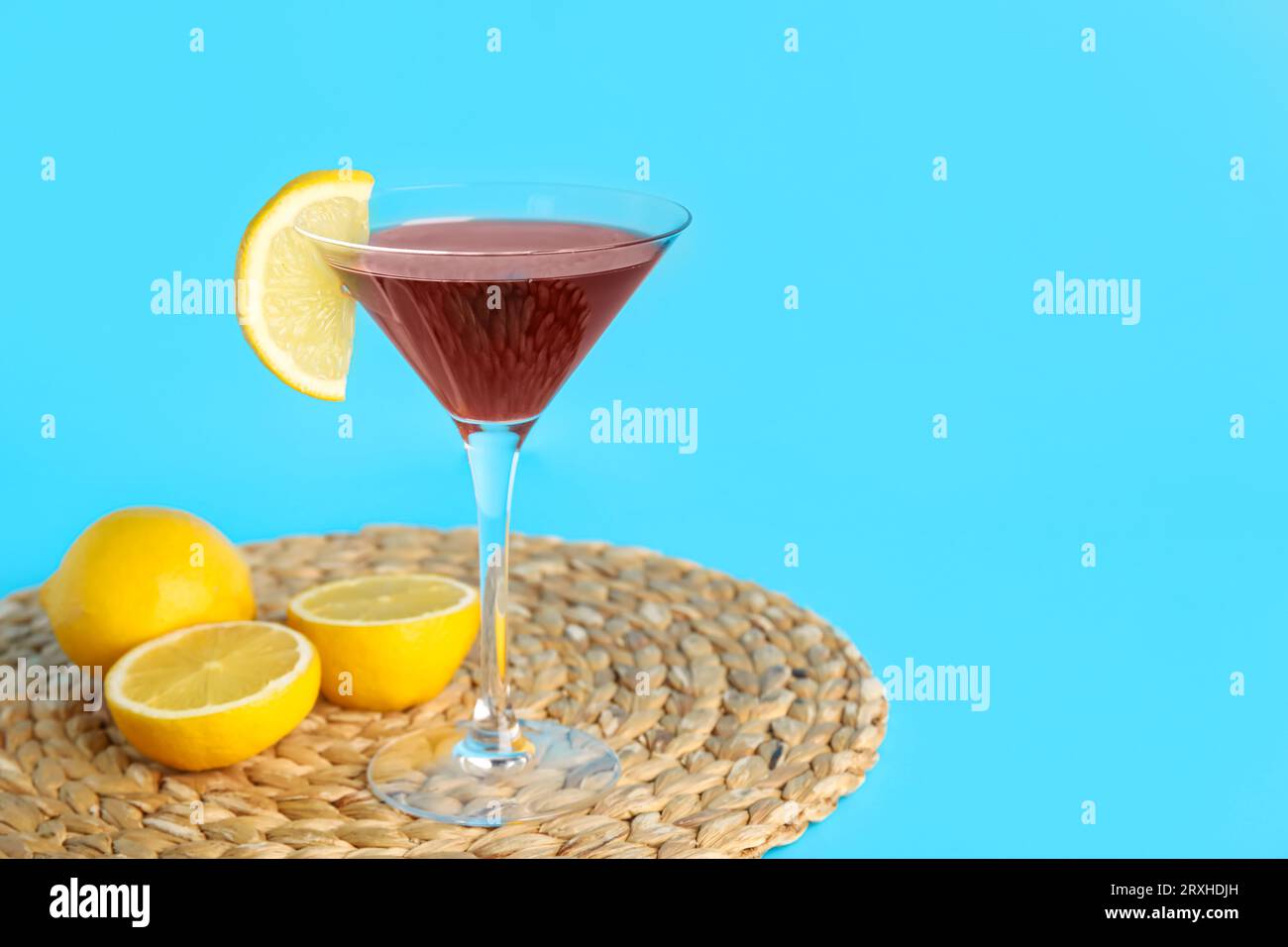 Glass of Cosmopolitan cocktail with lemon on blue background Stock ...
