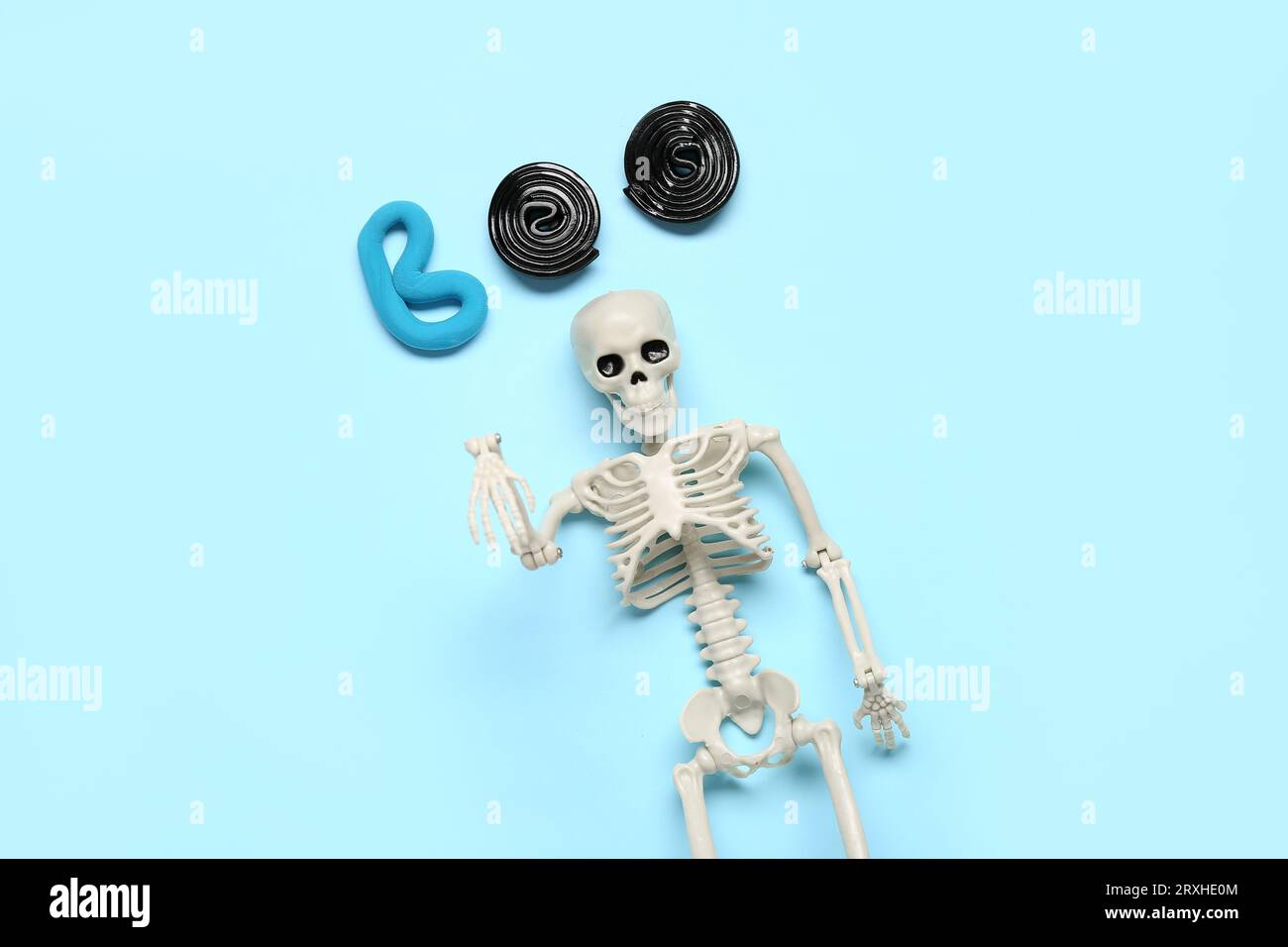 Halloween composition with skeleton and word BOO made from licorice ...