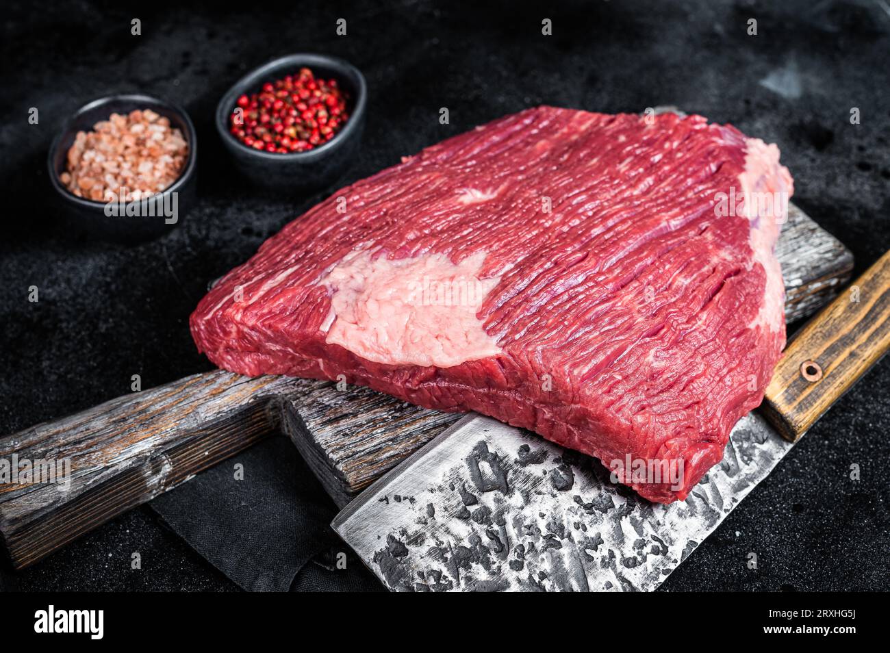 Uncooked Raw beef brisket meat on butcher board. Black background. Top ...