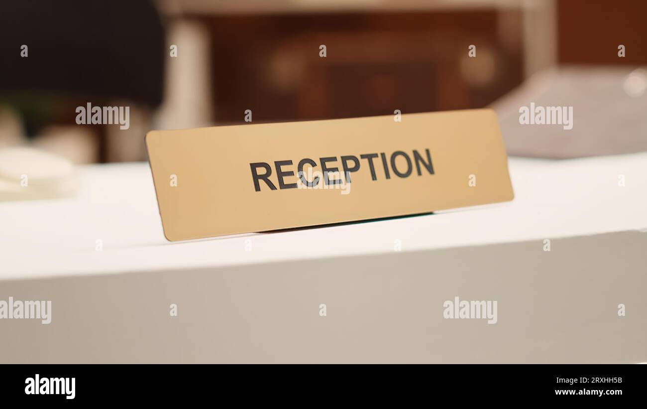 Close up of hotel lobby check in reception plaque sign and folders of ...