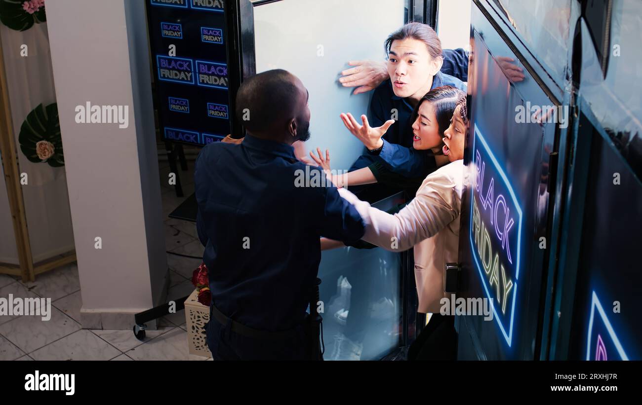 Impatient shoppers fighting staff to enter clothing store, pushing ...