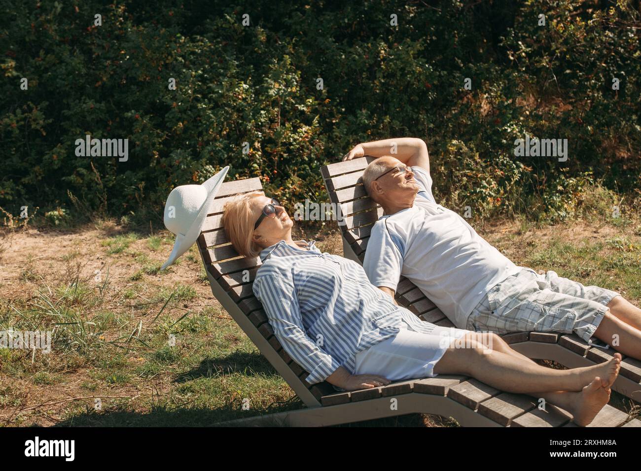 Old couple lying on sunbeds hi-res stock photography and images - Alamy
