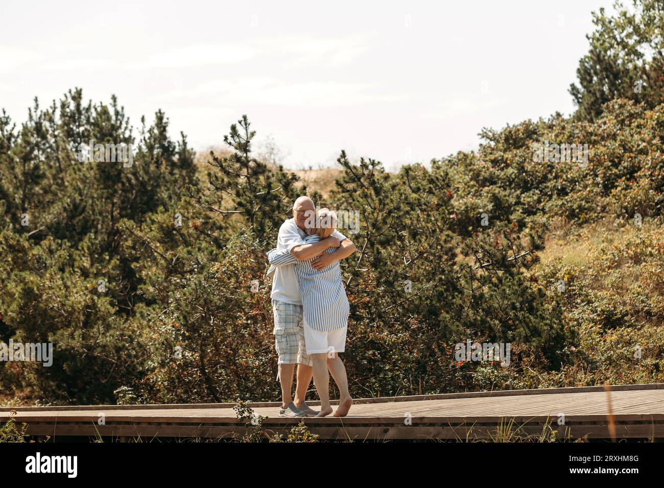 Emotional meeting of happy senior men and women on the path in the park ...