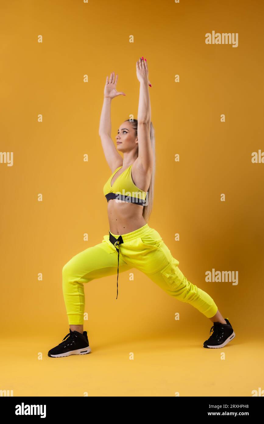 Beautiful girl in yellow outfit dancing zumba. Happy dance instructor ...