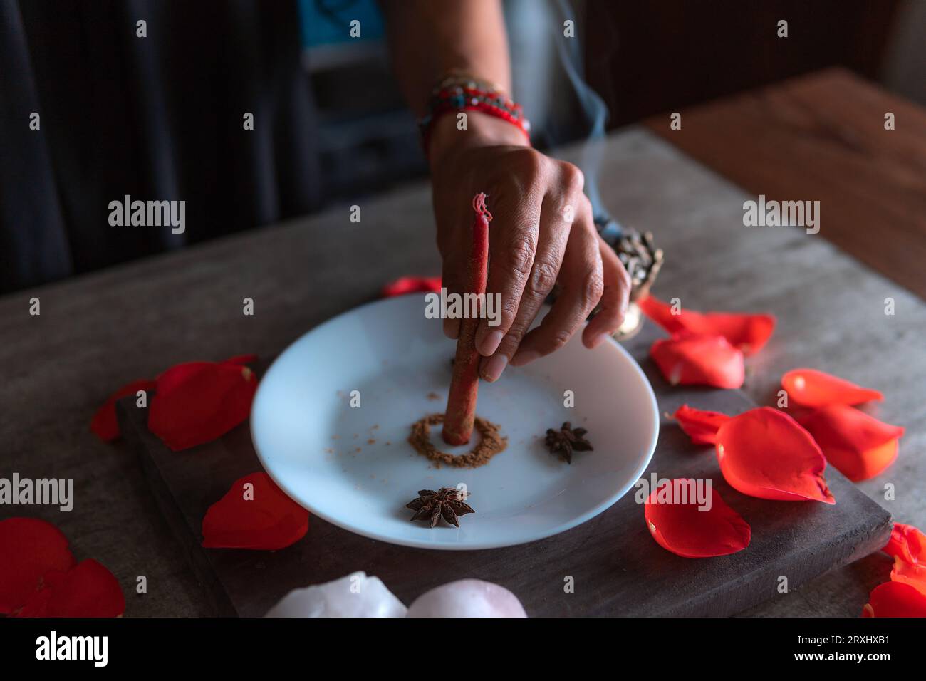 Preparation of a red candle with ground cinnamon, witch on the eve of ...