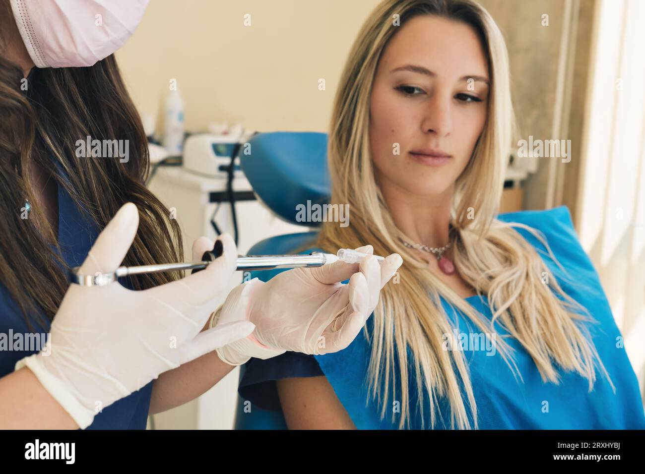 Dentist prepares anesthesia in dental office in background patient ...