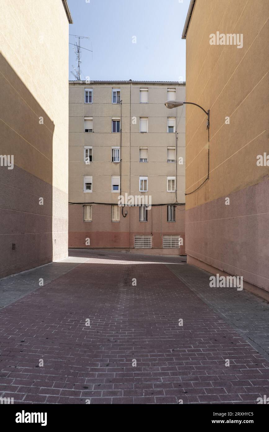 A pedestrian walkway between several facades of poor quality ...