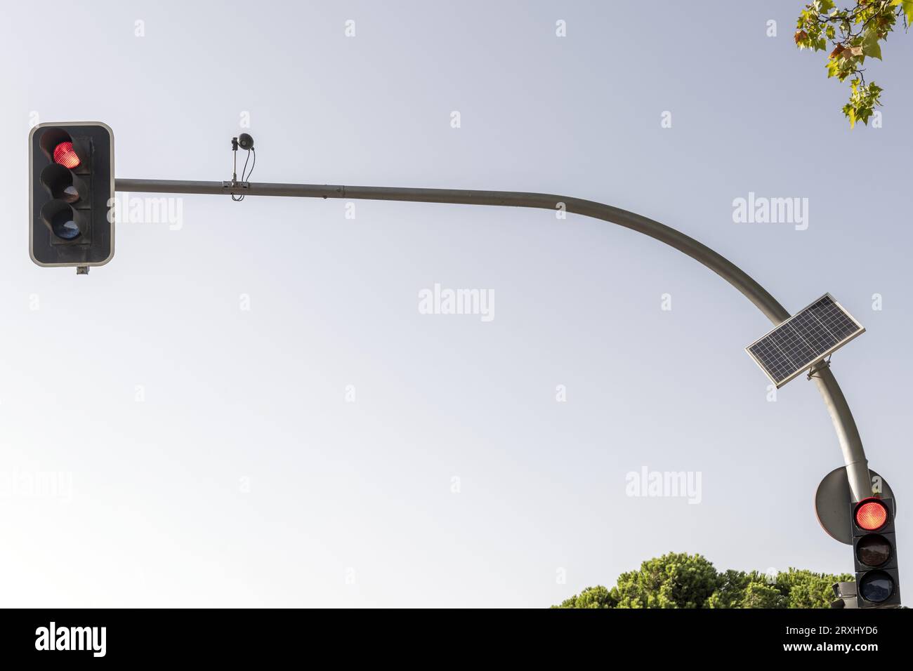 An urban traffic light with a red light, a traffic control camera and a ...