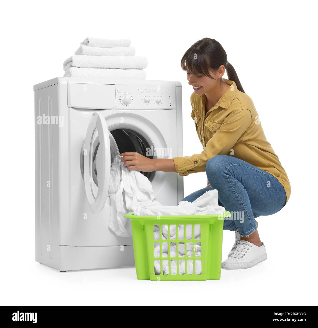 Beautiful woman taking laundry out of washing machine on white ...