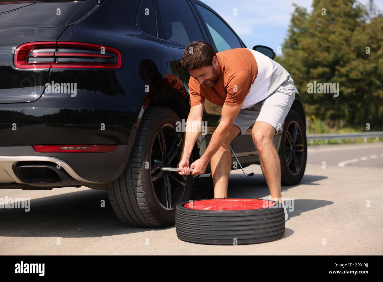 Man changing wheel of car on roadside outdoors Stock Photo - Alamy