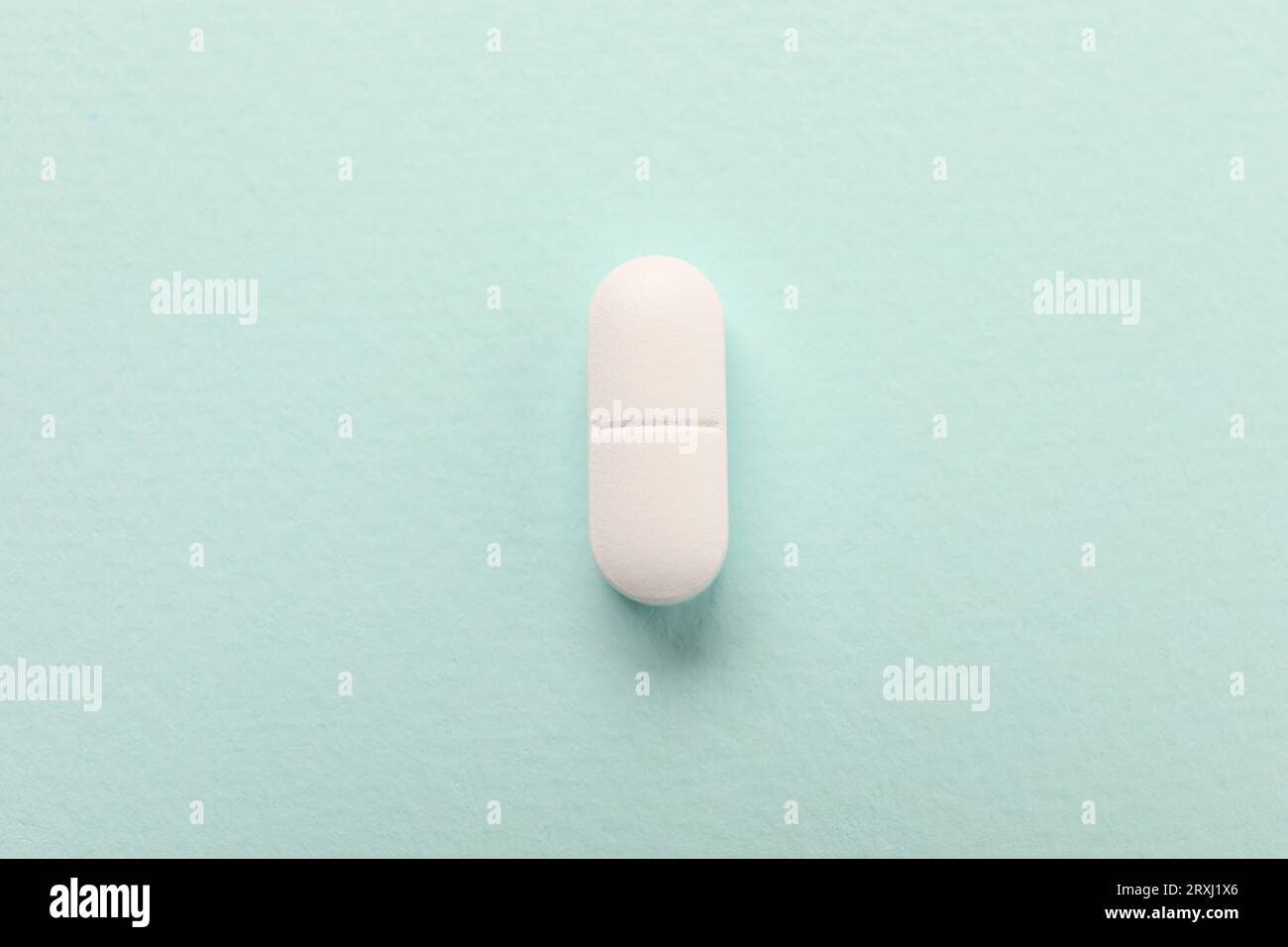 One white pill on mint background, top view Stock Photo - Alamy