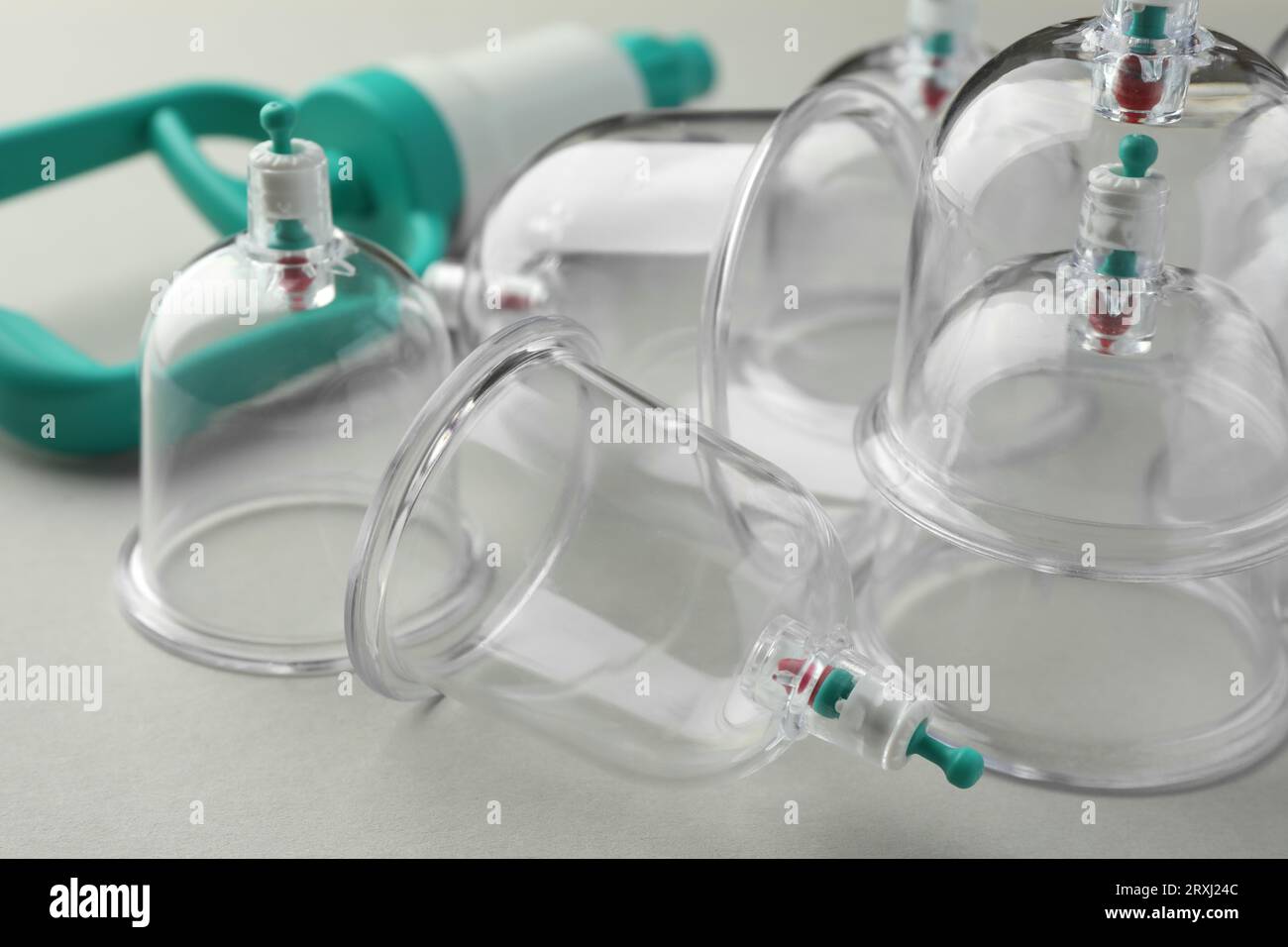 Plastic cups and hand pump on light grey background, closeup. Cupping ...