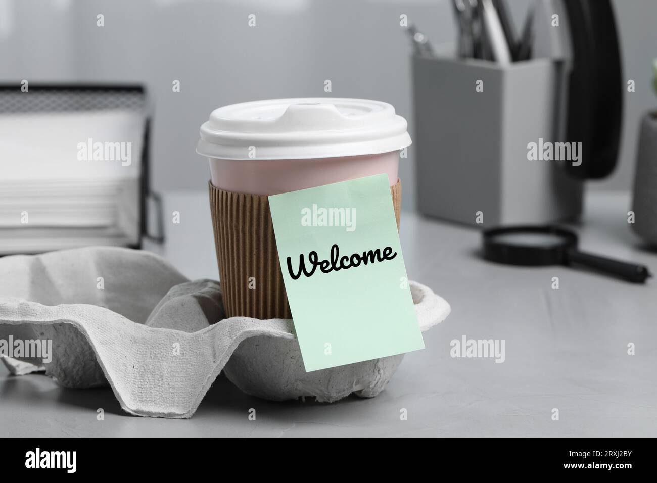 Sticky note with word Welcome attached to paper cup of coffee on office ...