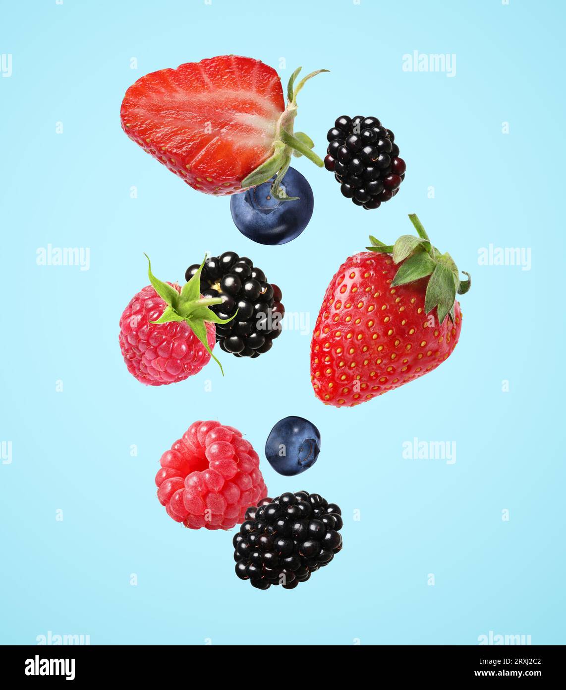 Many different fresh berries falling on light blue background Stock ...