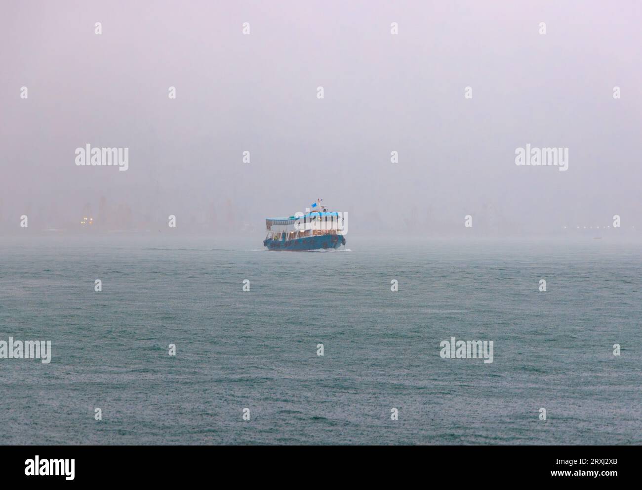 Passenger ferry navigates through fog in whiteout conditions on rainy ...
