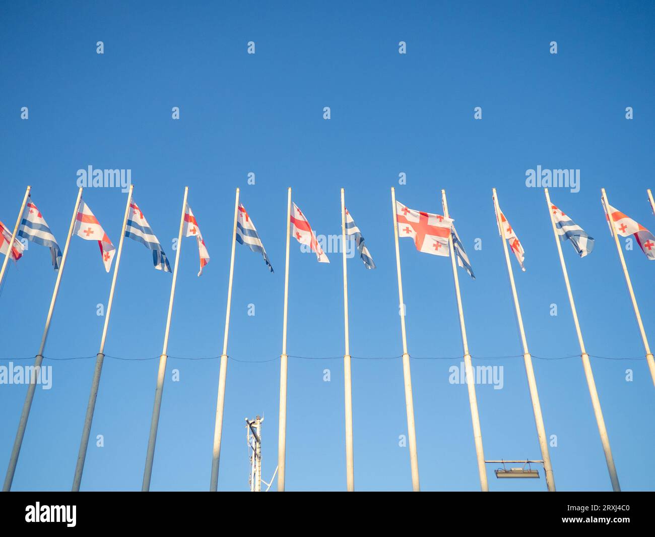 Flags of Georgia and Adjara. Many identical flags on flagpoles ...