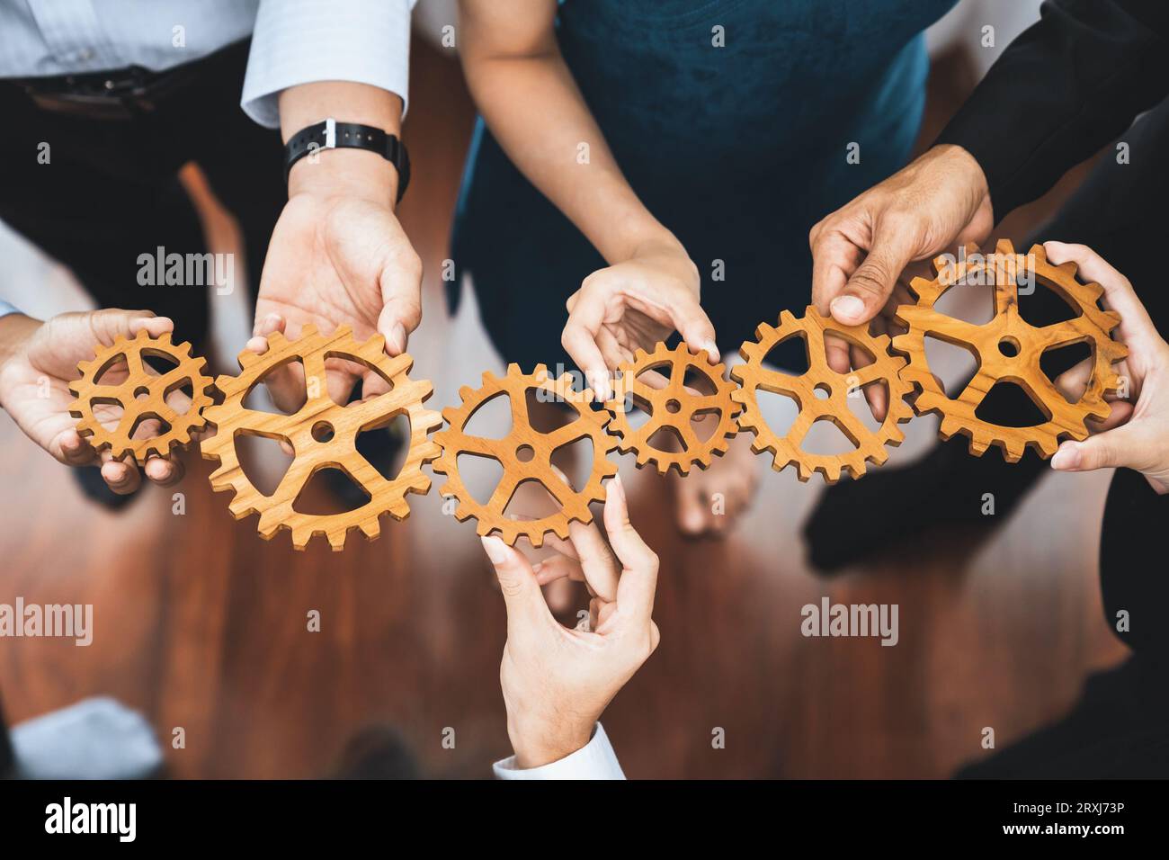 Office worker holding cog wheel as unity and teamwork in corporate ...