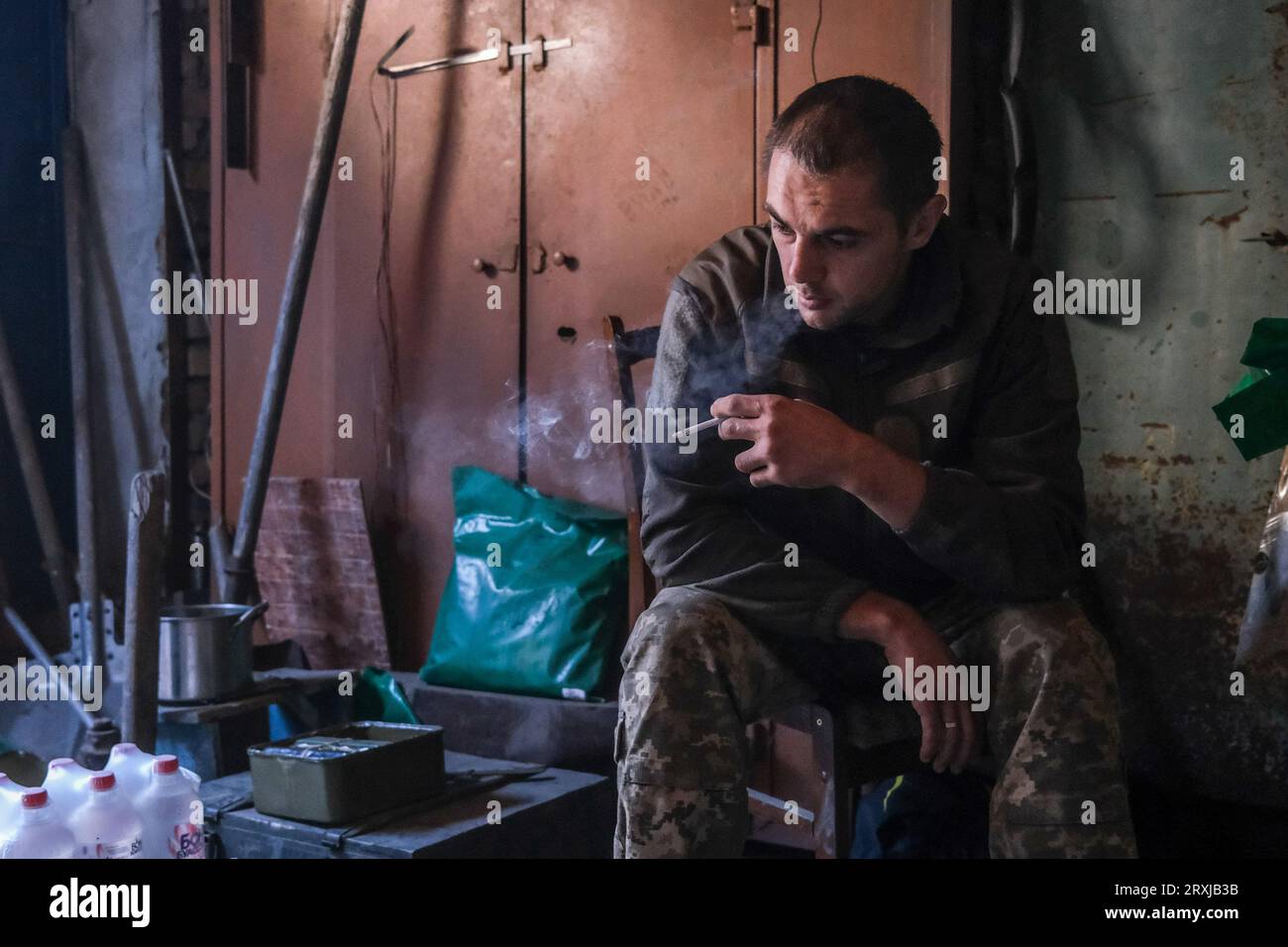 A Ukrainian soldier smokes a cigarette inside the damaged apartment ...