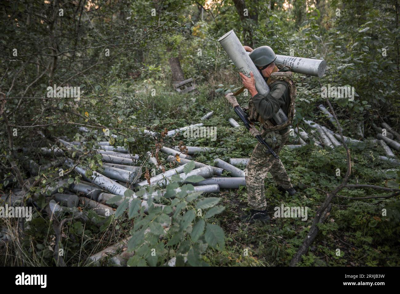 A Ukrainian soldier carries artillery shells to fire in the direction ...