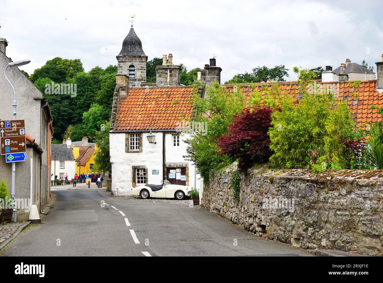 Vintage sports car parked beside a white stone building with a red tile ...