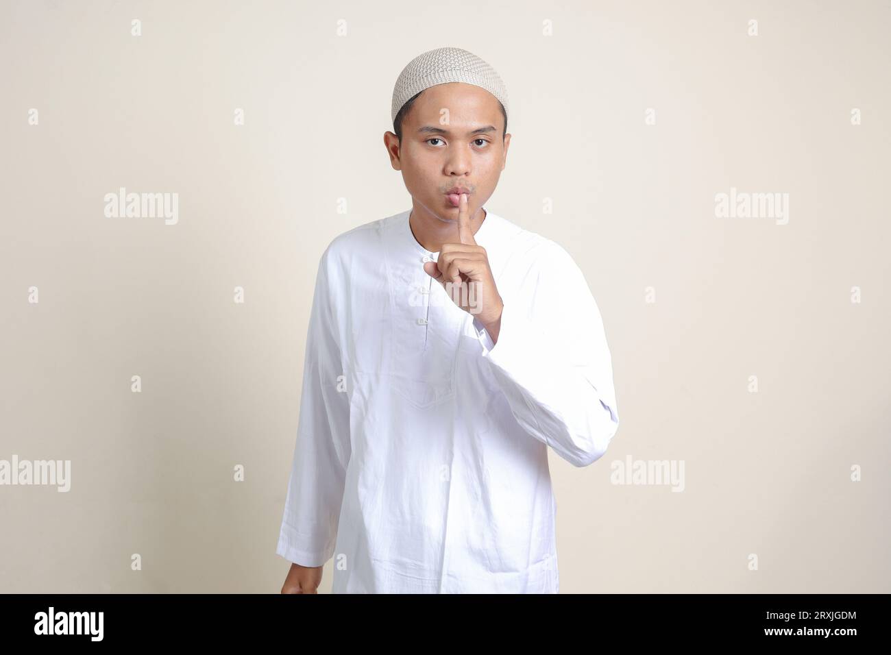 Portrait of attractive Asian muslim man in white shirt whispering ...