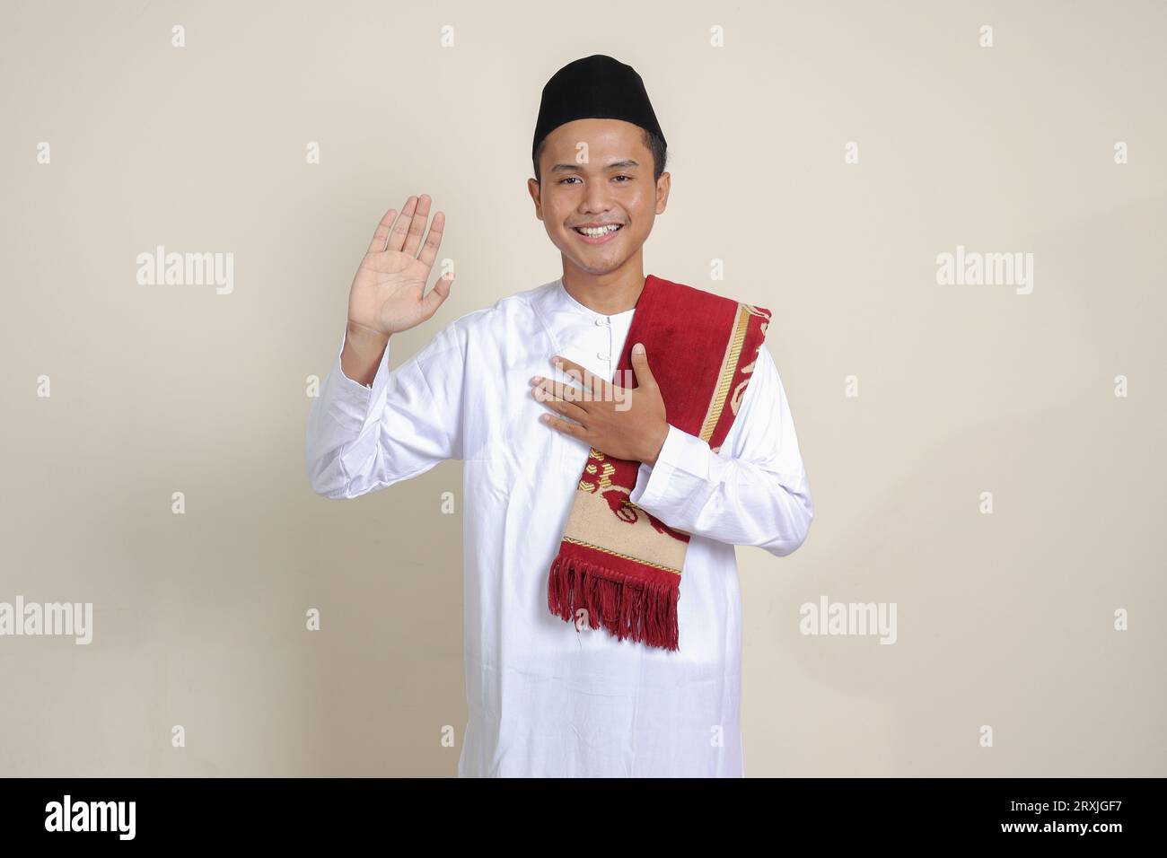 Portrait of attractive Asian muslim man in white shirt with skullcap ...