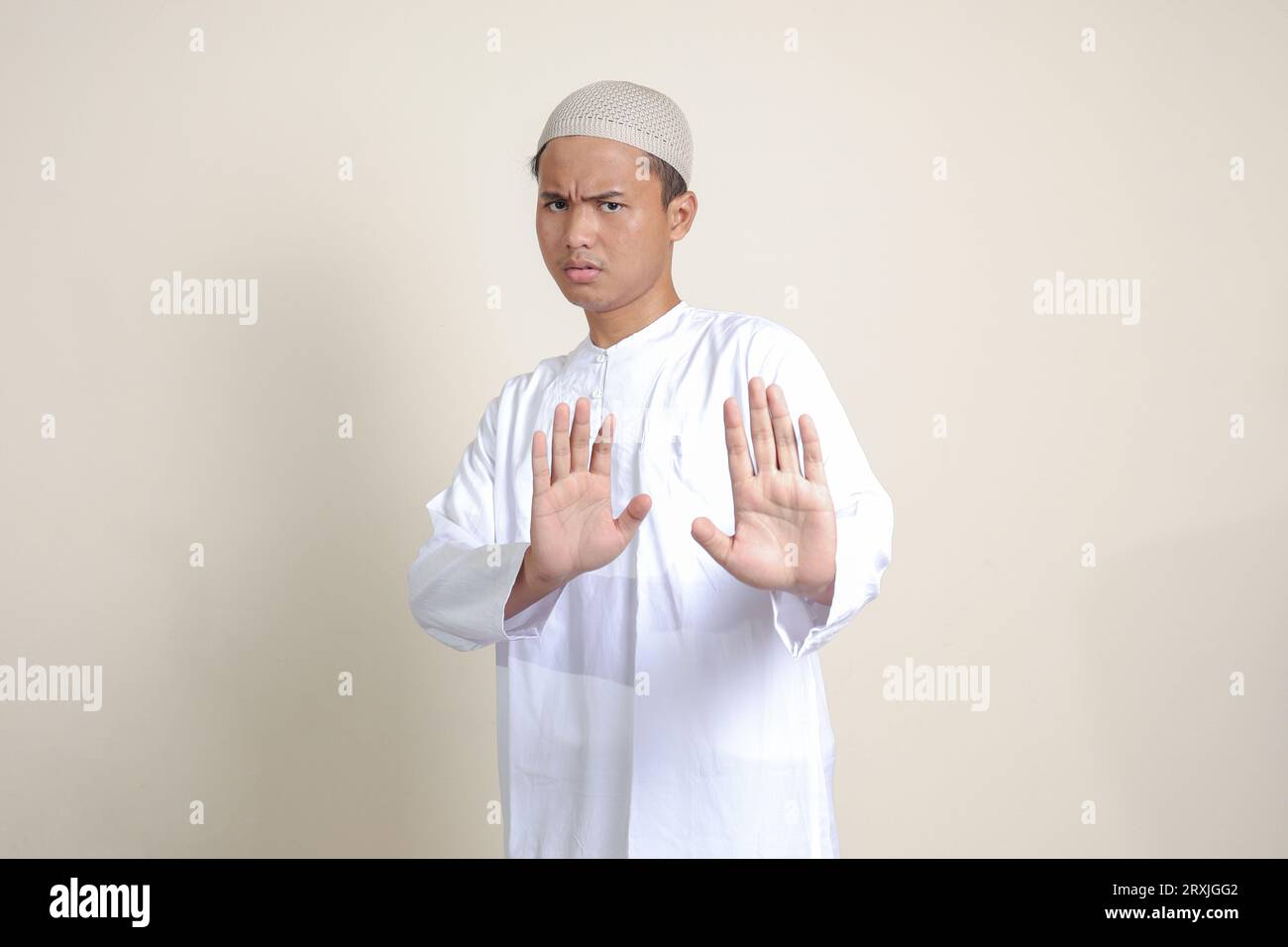 Portrait of attractive Asian muslim man in white shirt with skullcap ...