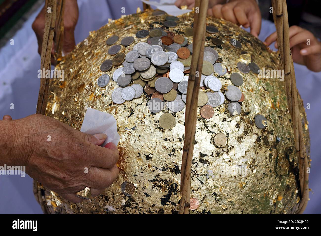 A photo of a stupa being gilded by young children and elderly people ...