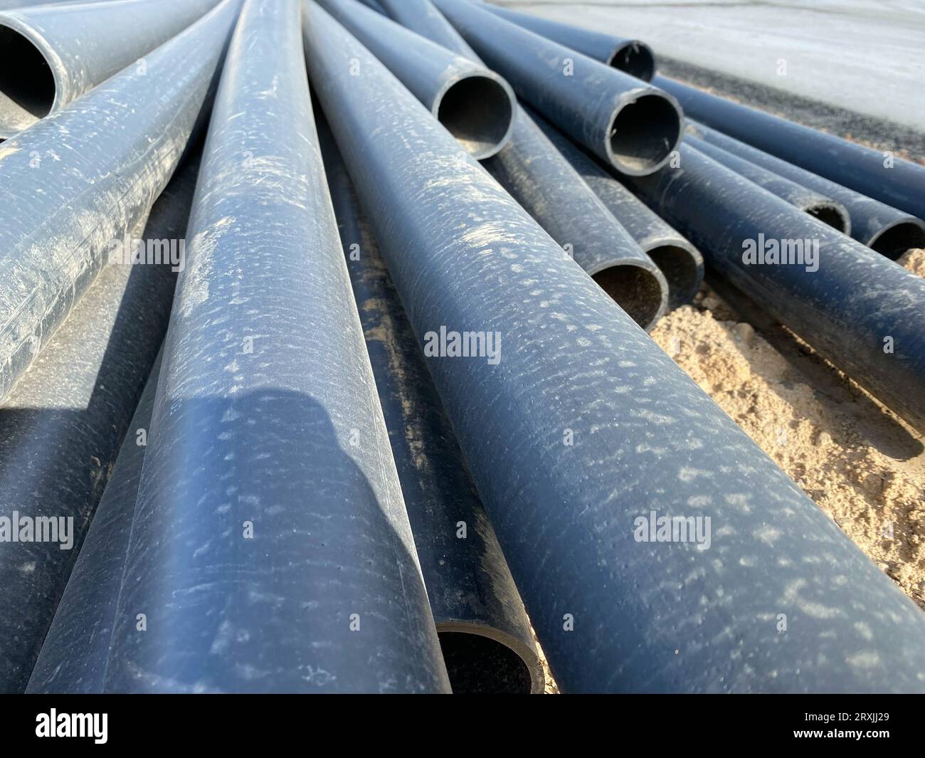 close-up Plastic main black pipes. A heap of polyethylene pipes for a ...