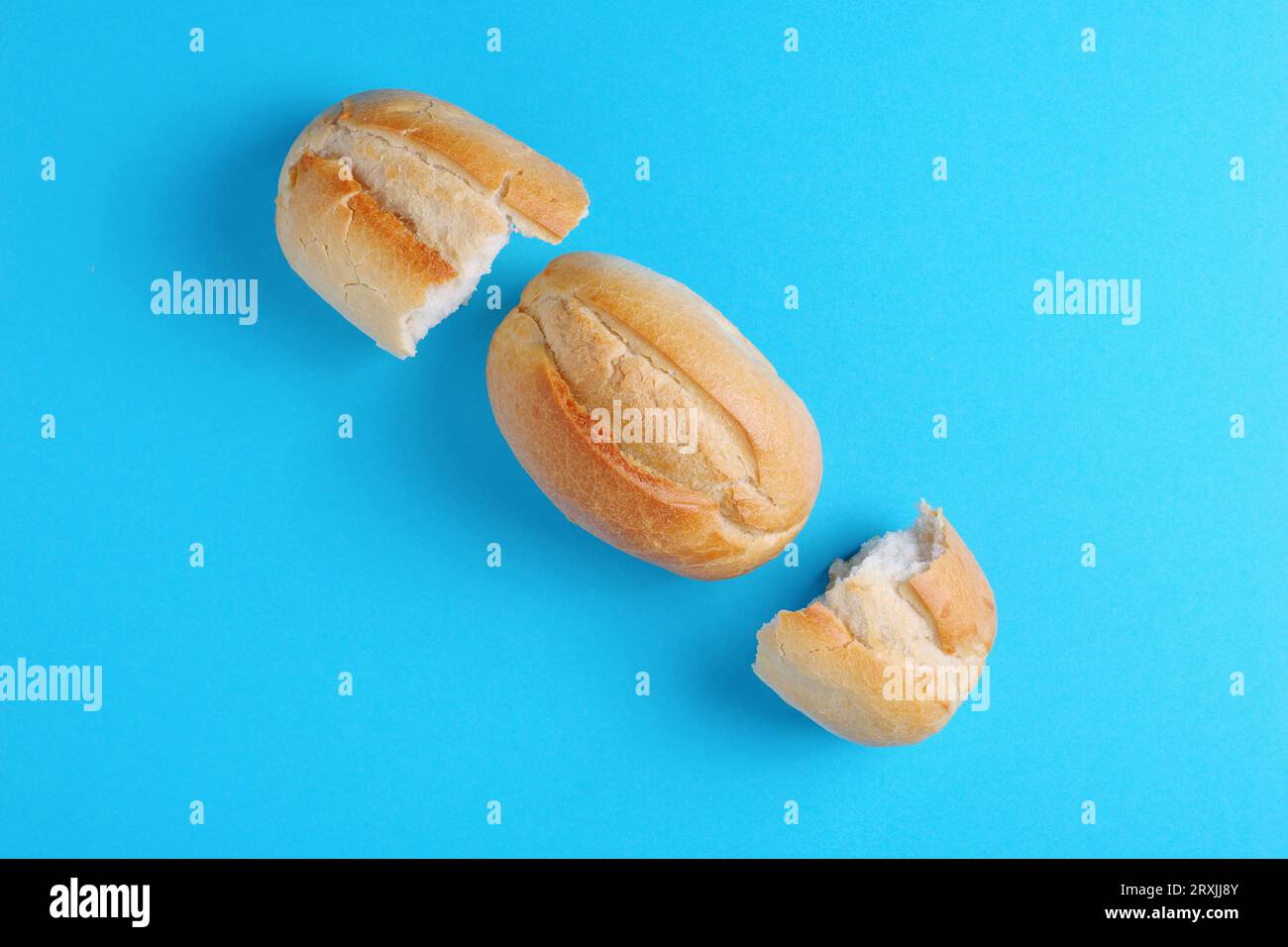 Loaves of bread whole and two half on blue background, top view Stock ...