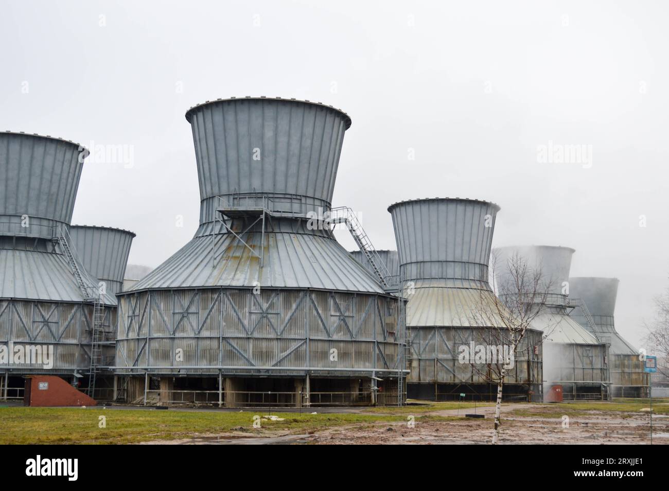 Large cooling towers in water and fog at an oil refinery, petrochemical ...