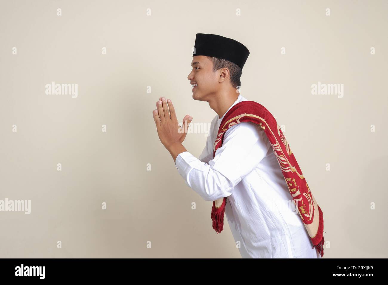 Portrait of attractive Asian muslim man in white shirt with skullcap ...