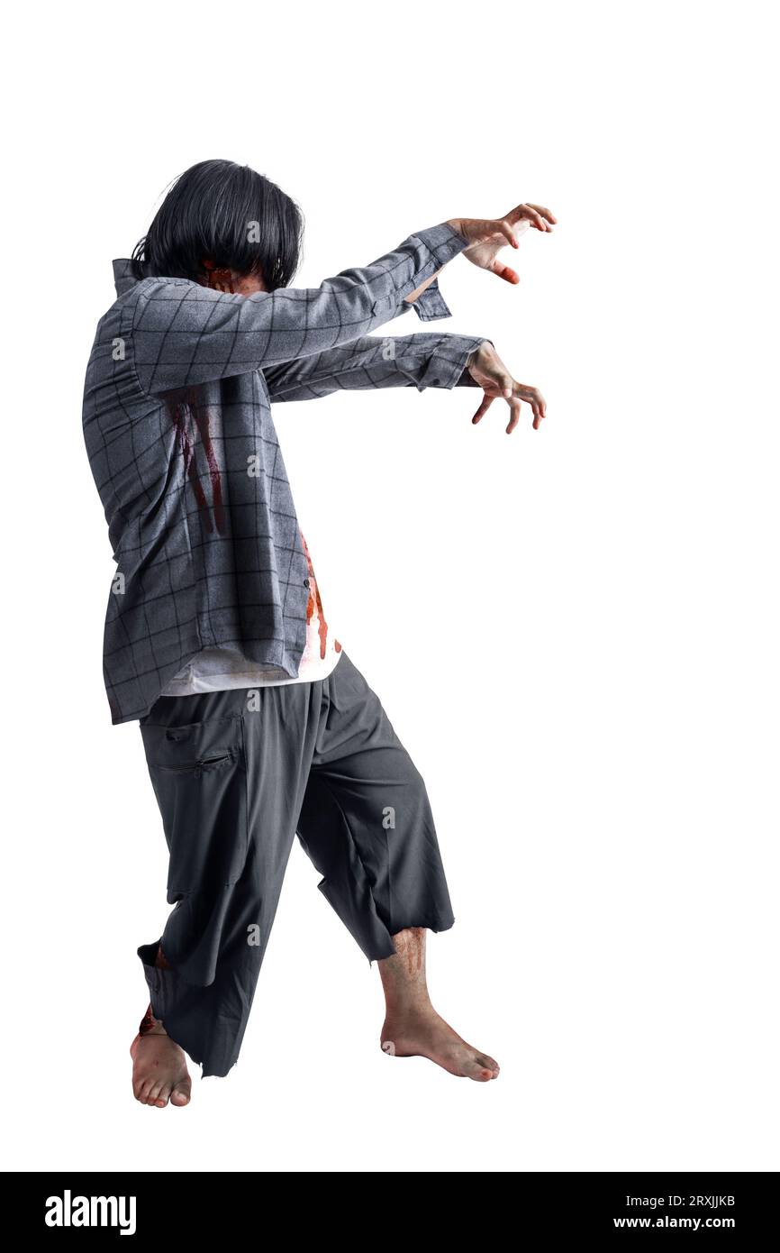 A scary zombie with blood and wounds on his body walking isolated over ...
