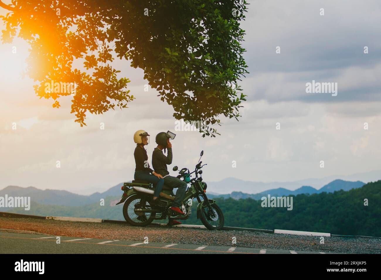 couples wearing safety helmet sitting on small enduro motorcycle ...