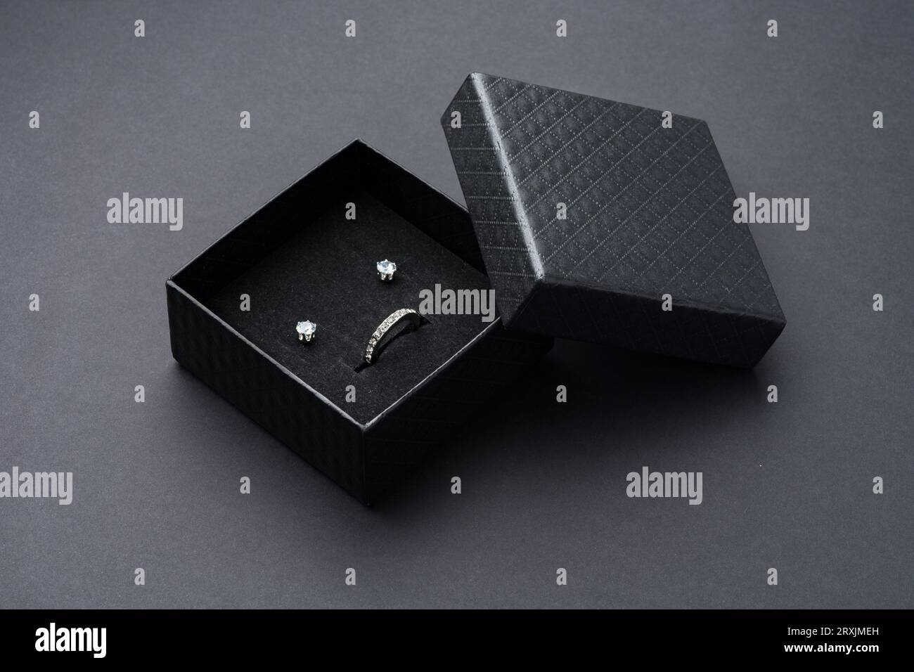 Open jewelry box on black paper background Stock Photo - Alamy