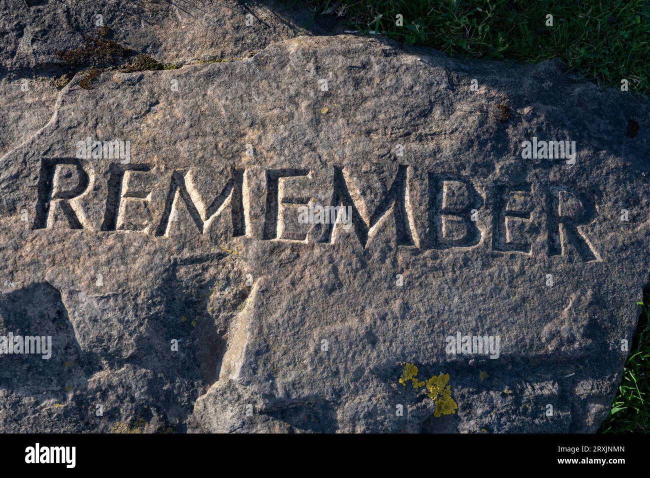 Remember carved into weathered and textured stone block Stock Photo - Alamy