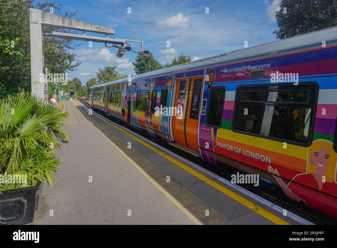A TfL Overground train in a colourful painting scheme at Kew station ...