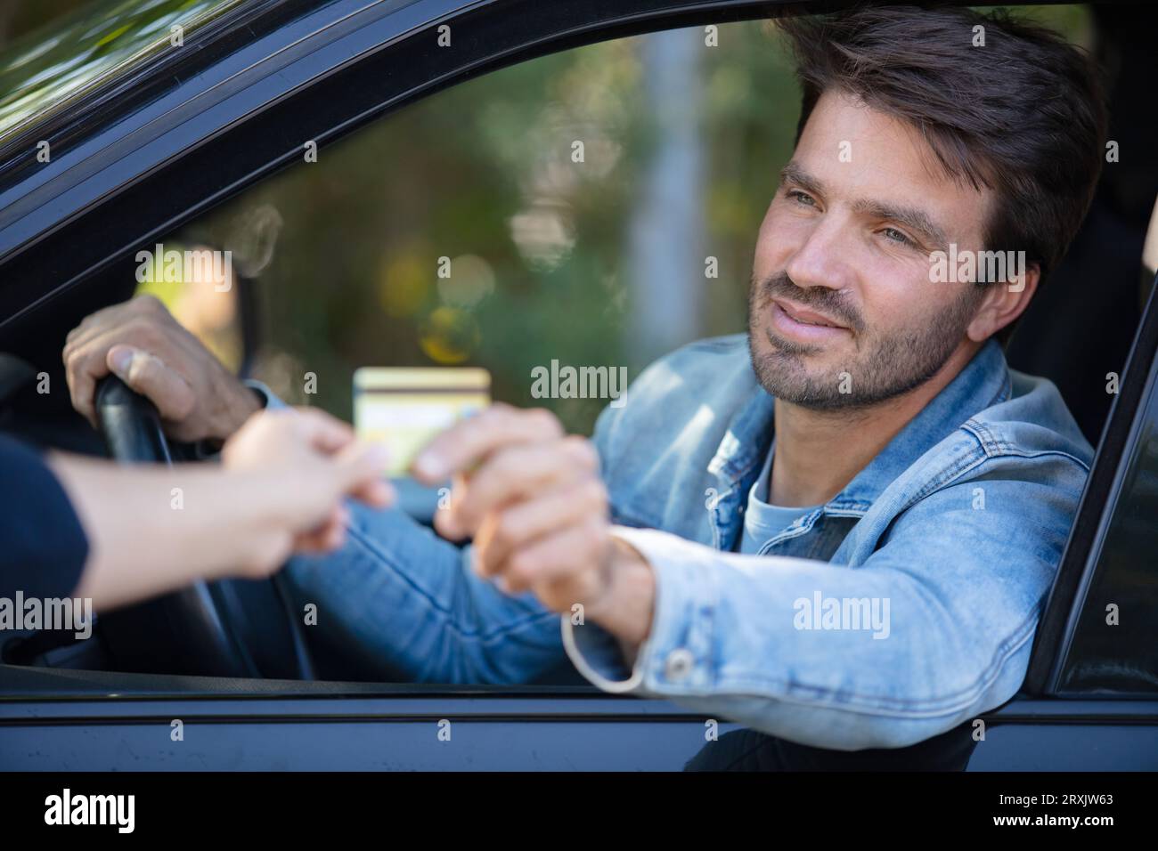 man paying money at toll booth Stock Photo - Alamy