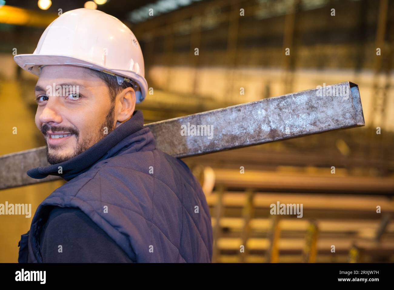 construction worker carrying reinforcement rods at building site Stock ...
