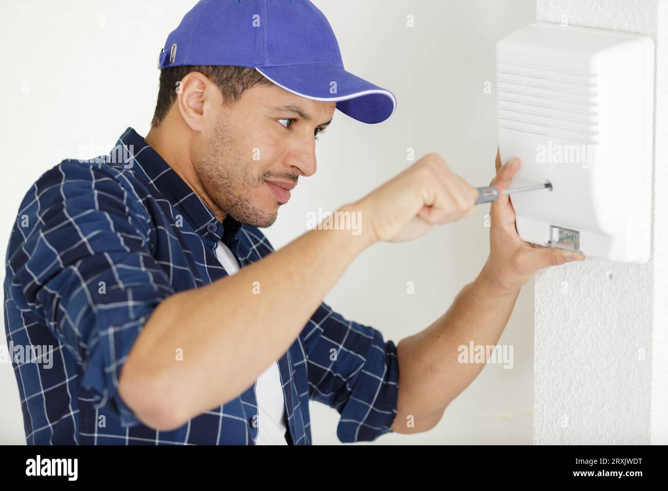 technician installing security system door sensor using screwdriver ...