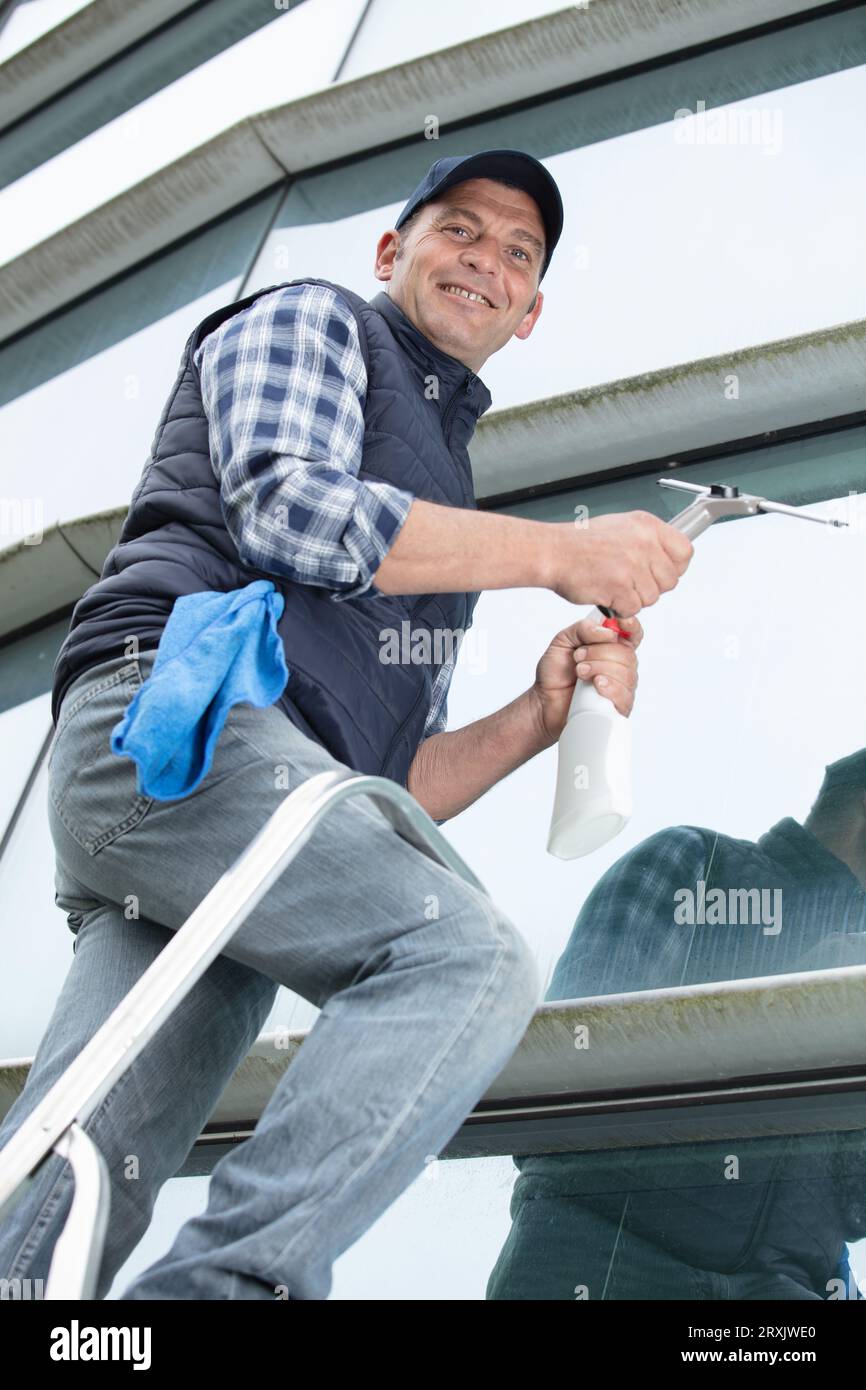 man on a ladder cleaning a window Stock Photo - Alamy