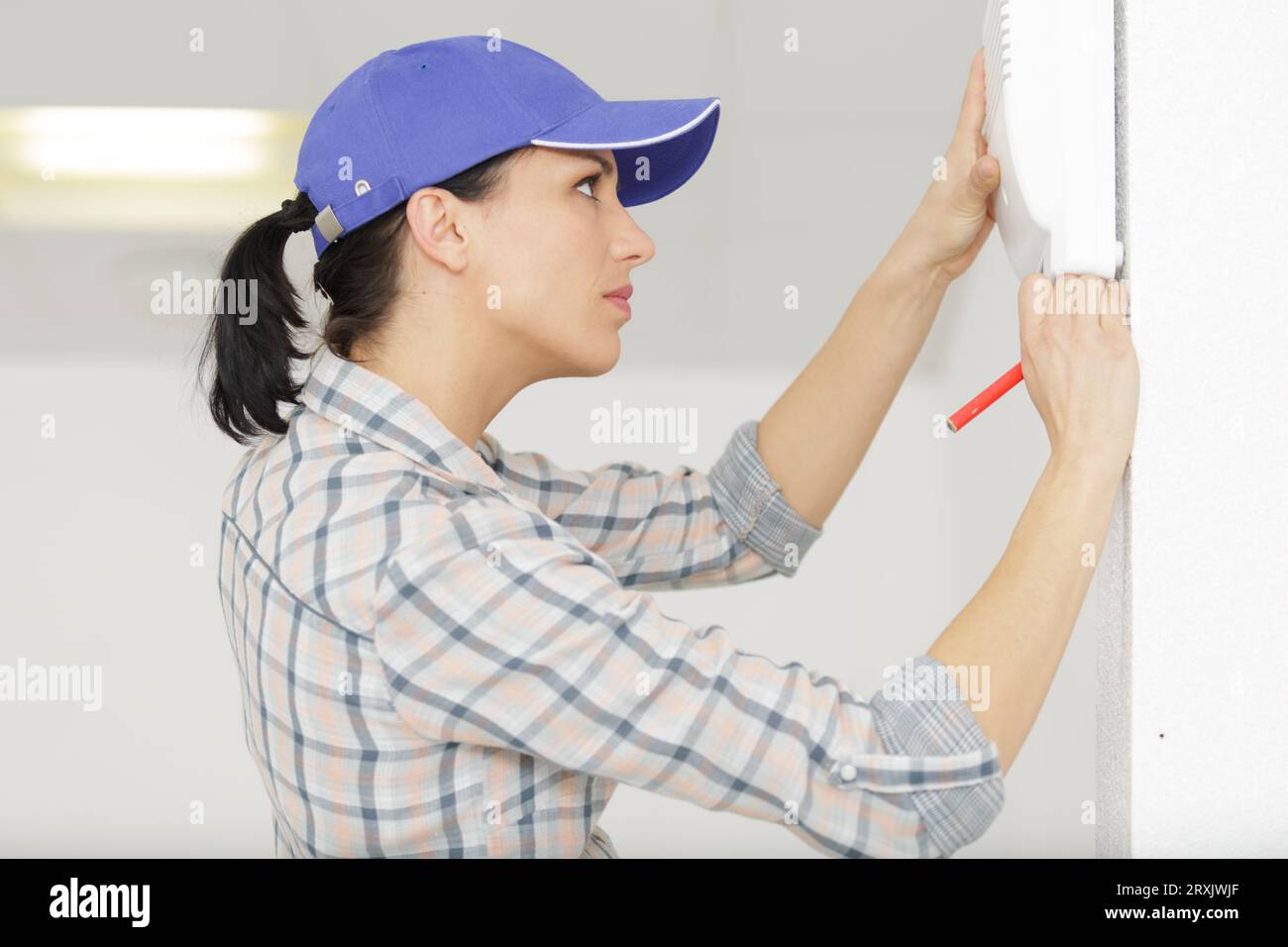 female technician installing alarm using pencil Stock Photo - Alamy