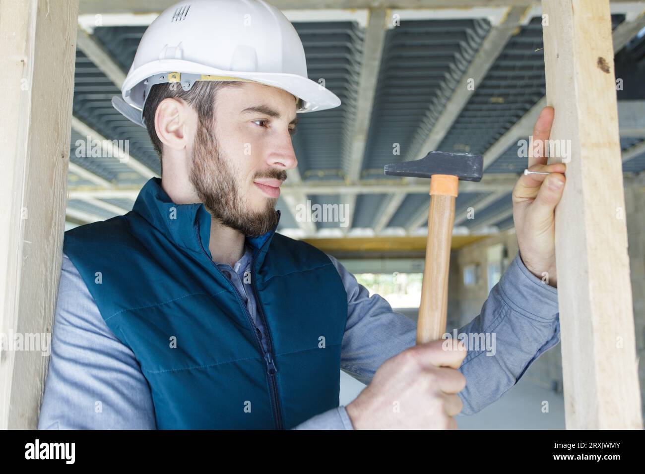 confident man builder hammer wood structure indoors Stock Photo - Alamy