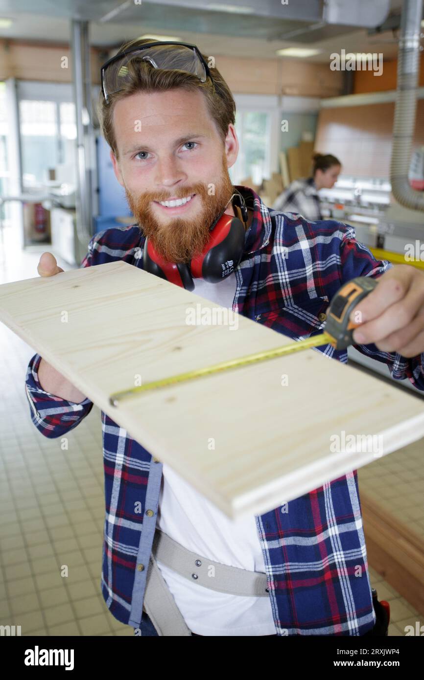 man measuring wood with tape measure Stock Photo - Alamy