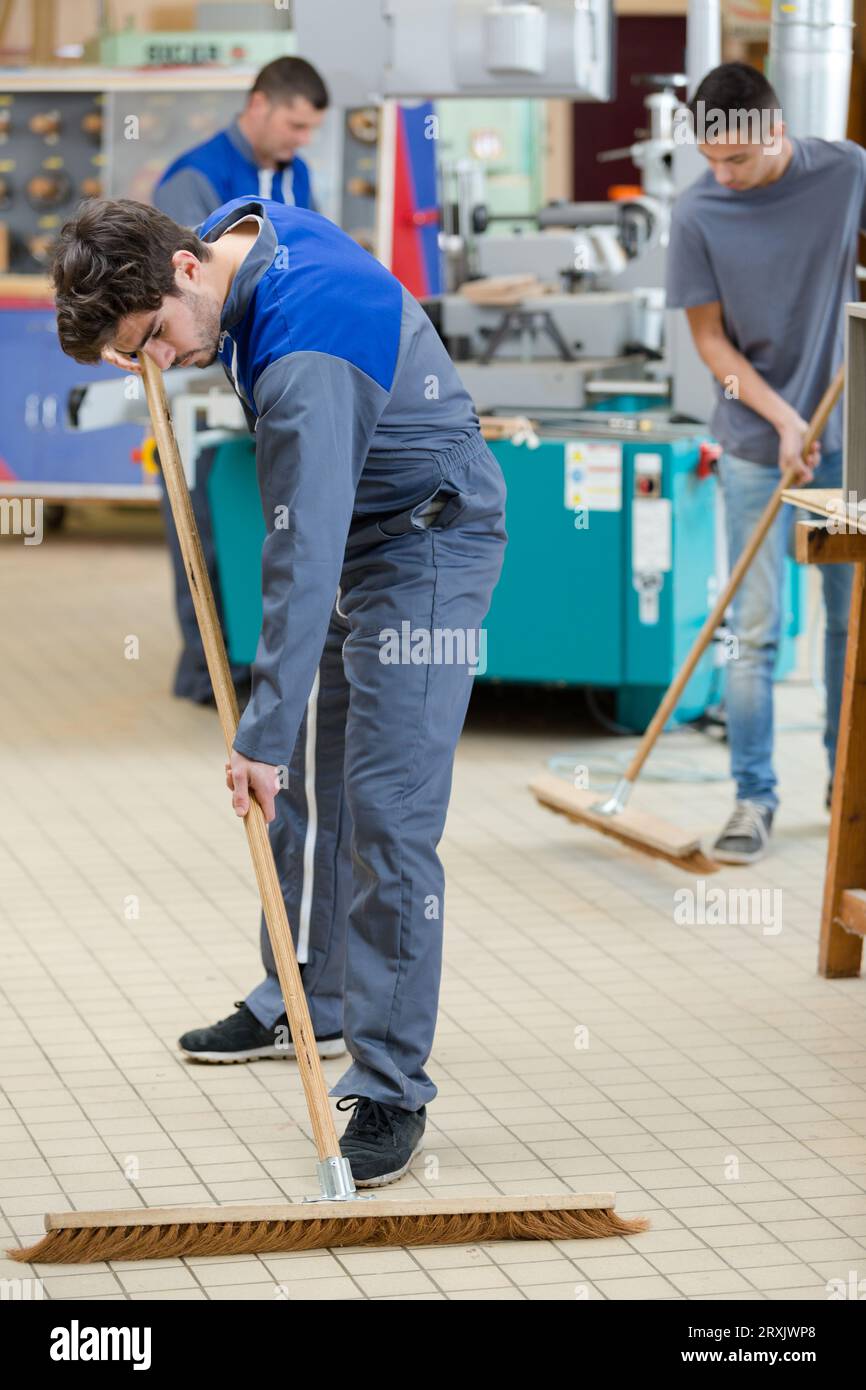 young workers sweeping up the factory floor Stock Photo - Alamy